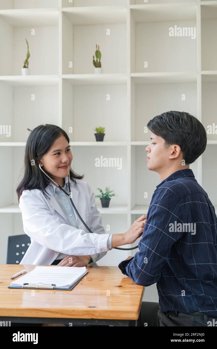 Asian man patient are checked up his health while a woman doctor use a ...