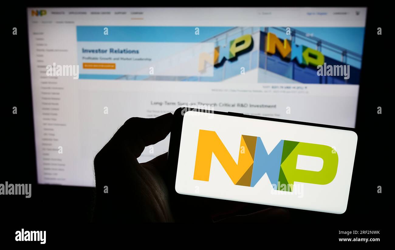 Person holding smartphone with logo of Dutch company NXP Semiconductors ...