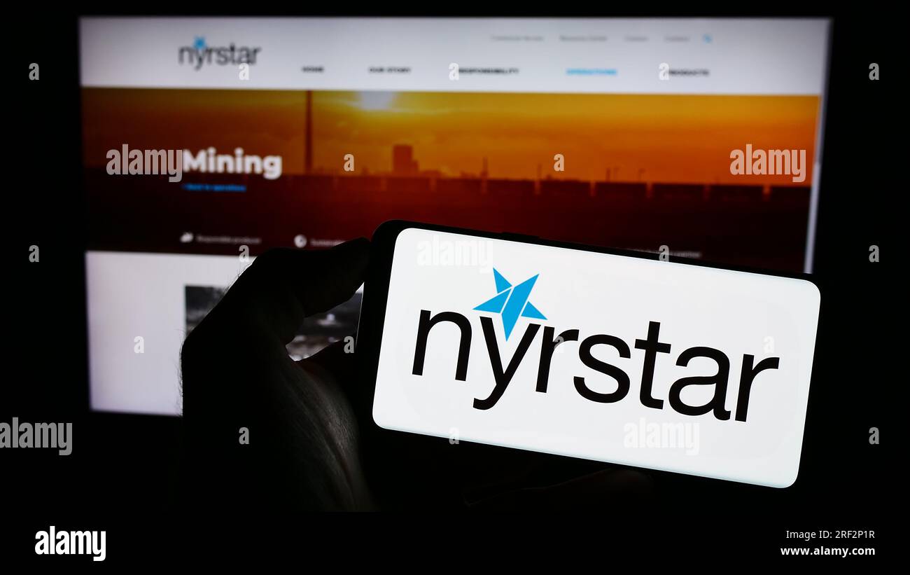 Person holding mobile phone with logo of Dutch mining company Nyrstar ...