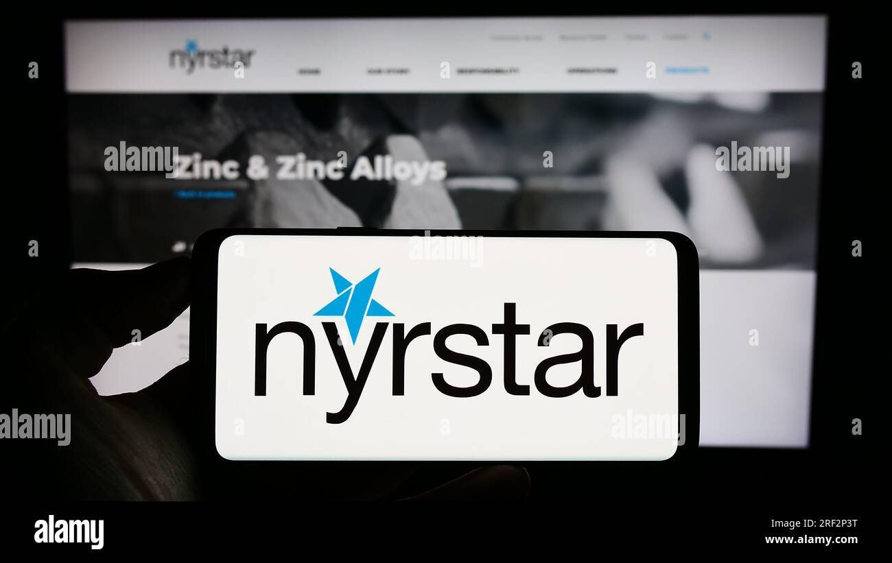 Person holding cellphone with logo of Dutch mining company Nyrstar on ...