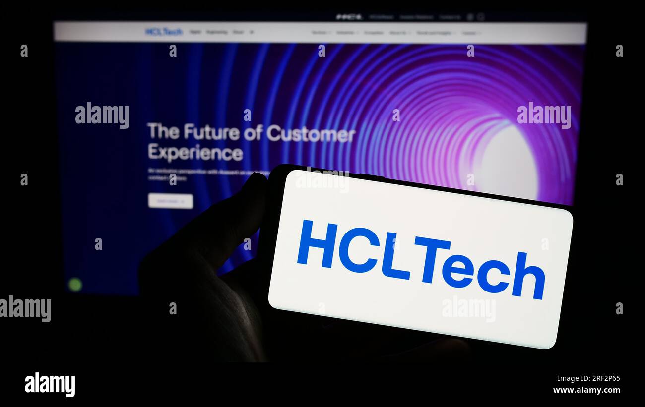 Person holding smartphone with logo of Indian company HCL Technologies Limited on screen in ...