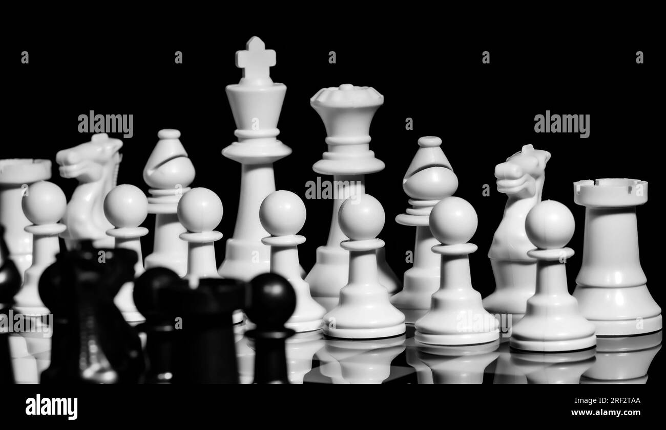 Close up of Chess pieces on a reflective mirror board surface with a ...