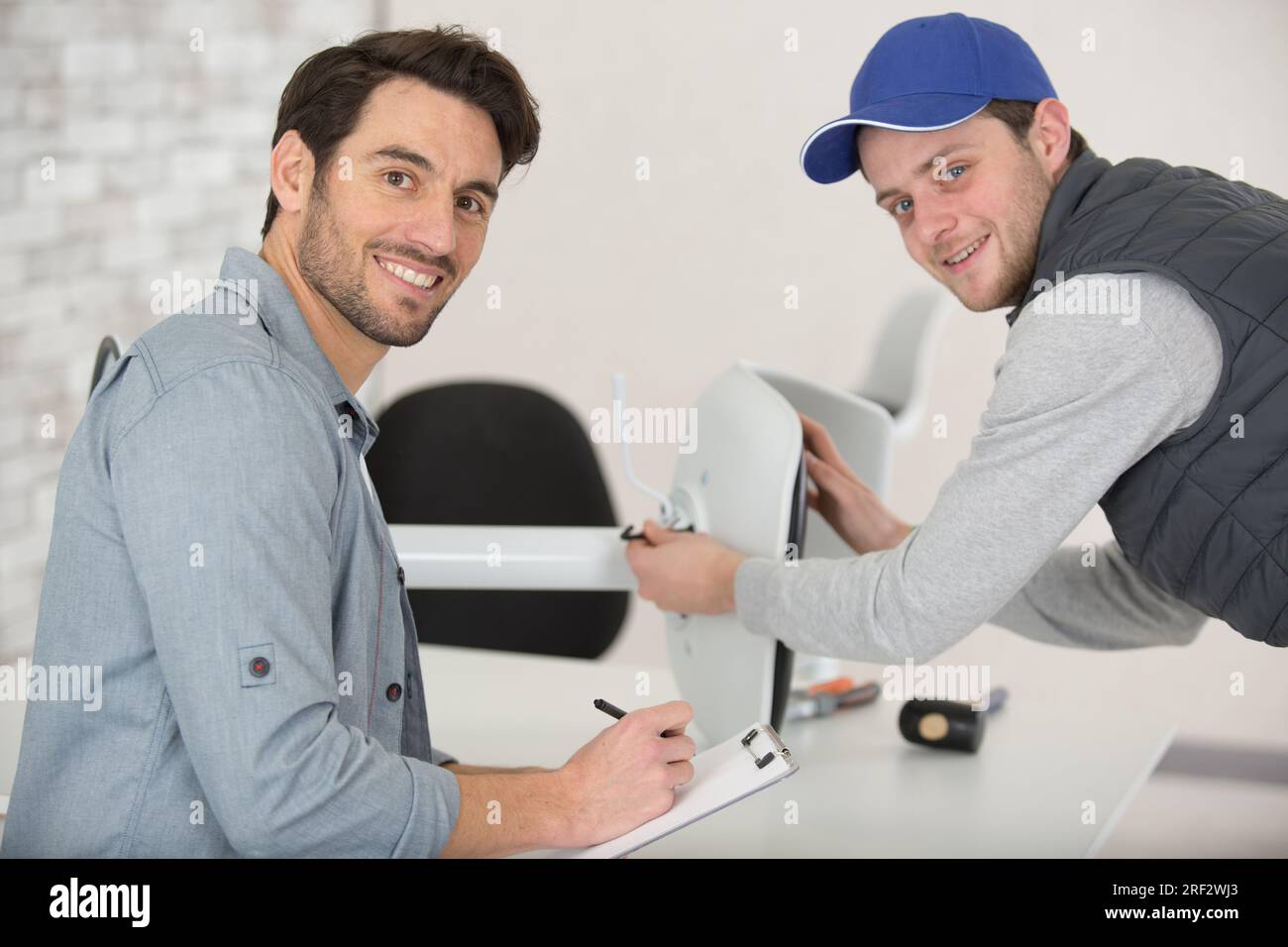 men fixing caster roller wheel of a wheel Stock Photo - Alamy