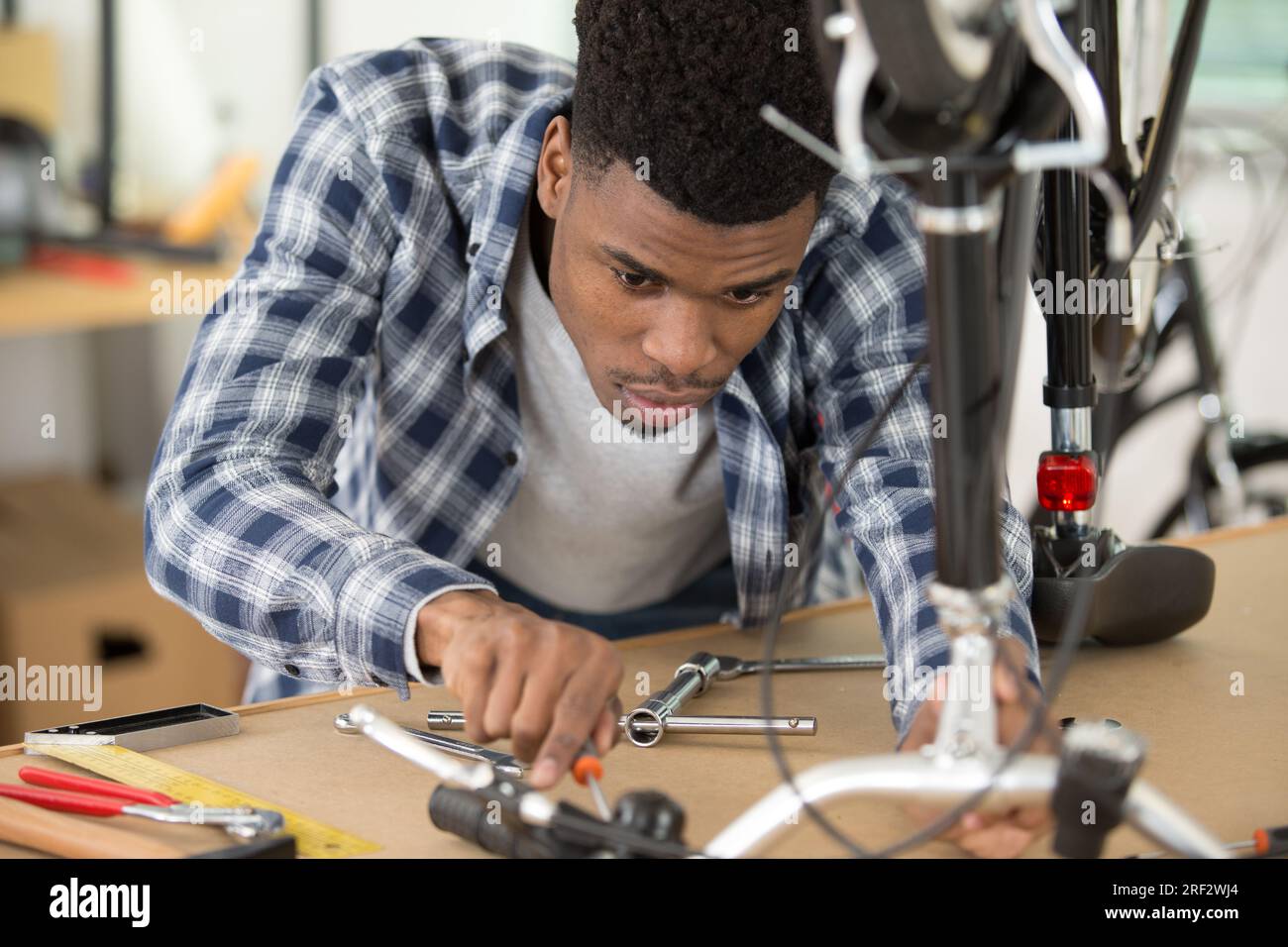 Young man fixing bike hi-res stock photography and images - Alamy