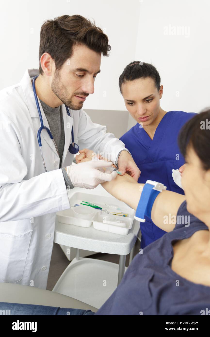 junior doctor watching blood pressure check on patient Stock Photo - Alamy