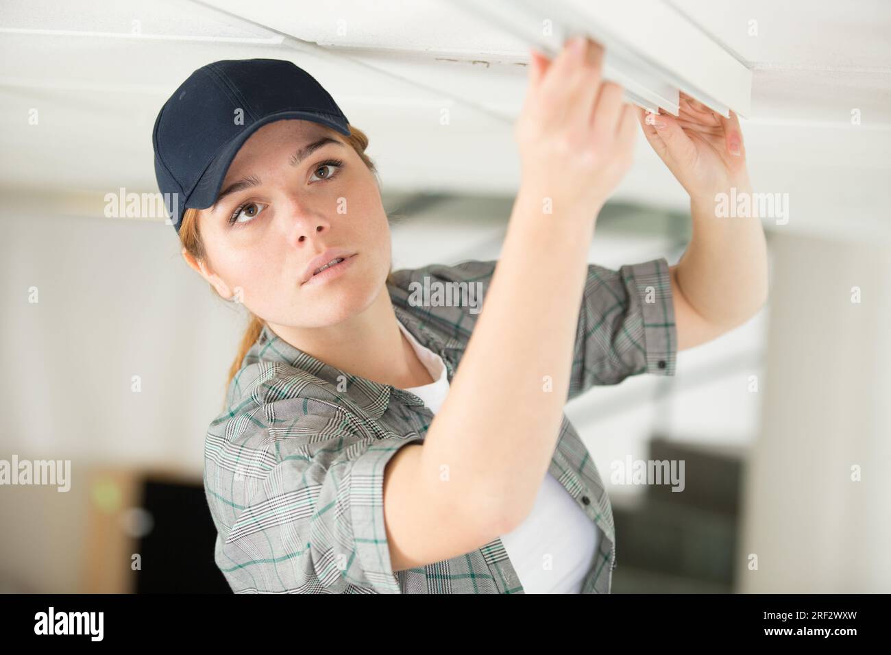a woman fixing a light Stock Photo - Alamy