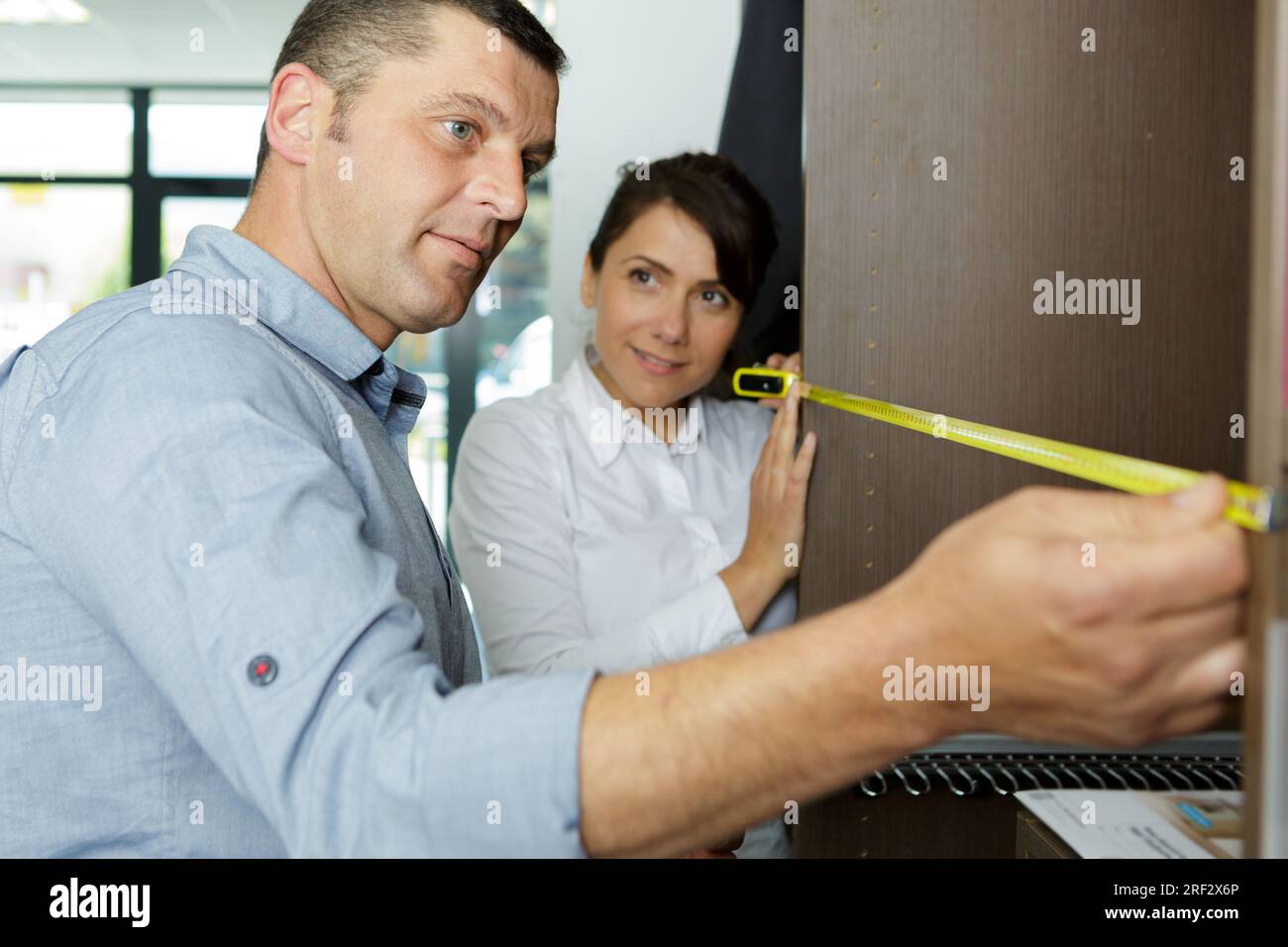 a handyman measuring a wardrobe Stock Photo - Alamy