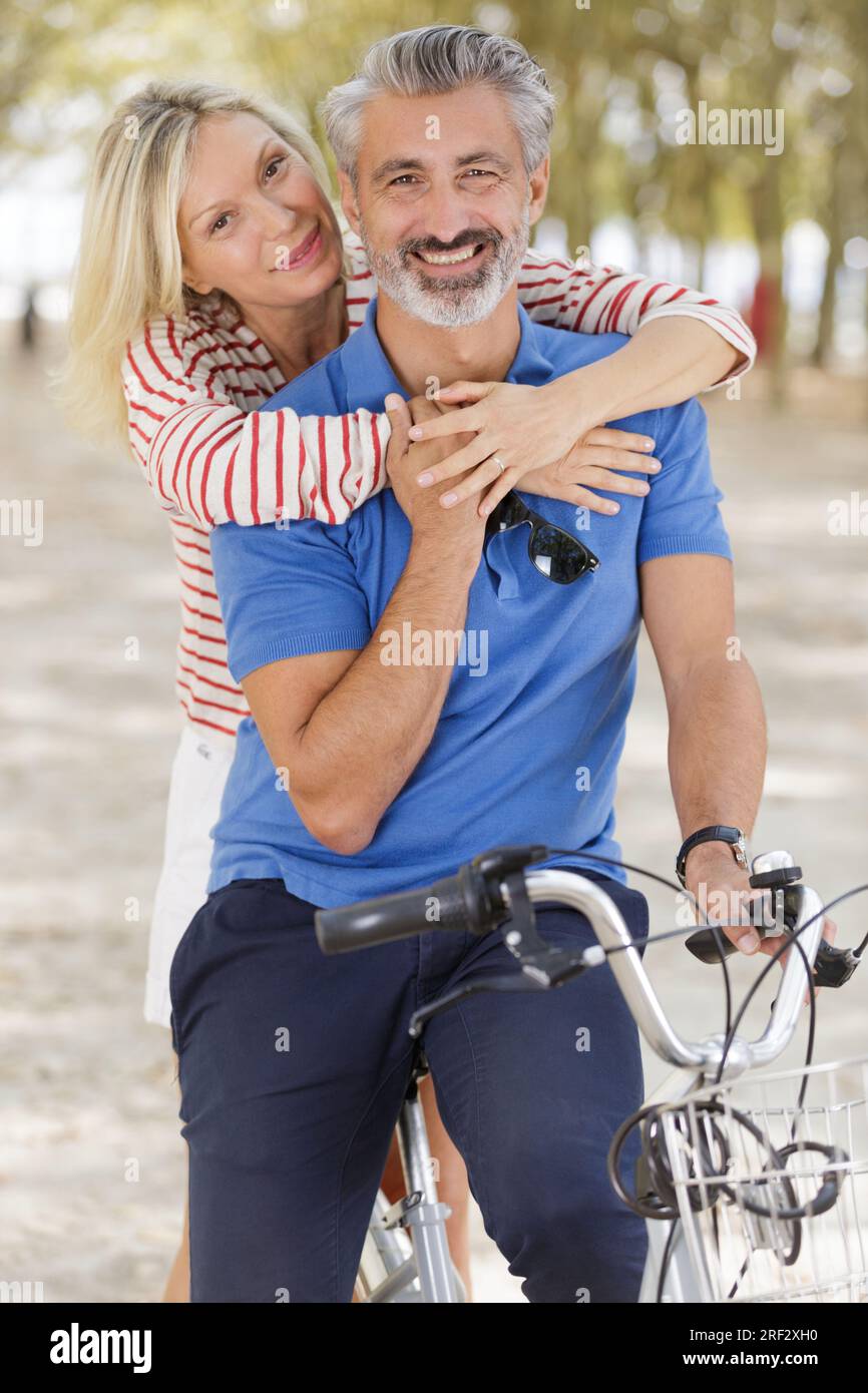 active mature couple riding bikes during summer vacation Stock Photo ...