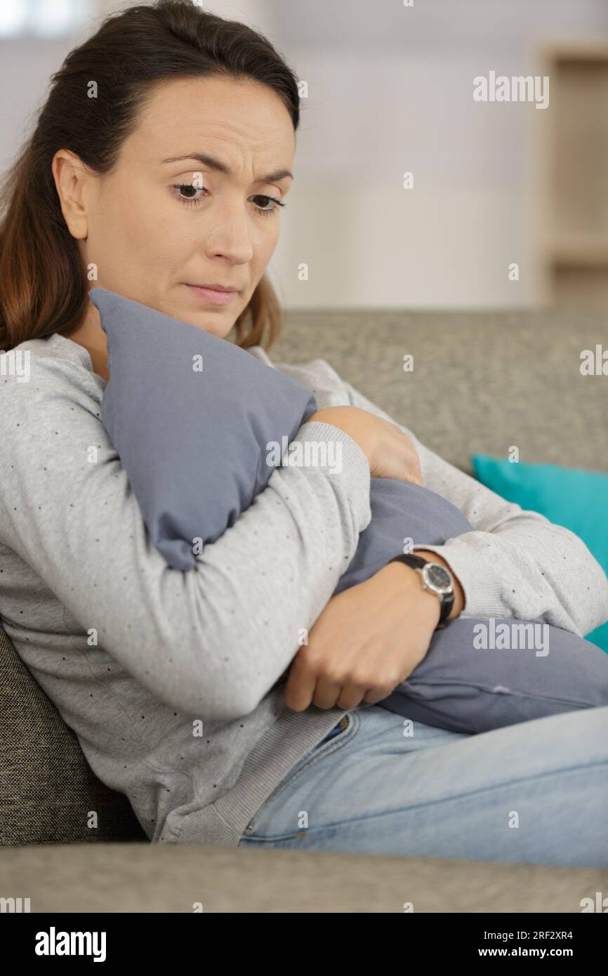 sad woman hugging a pillow Stock Photo - Alamy