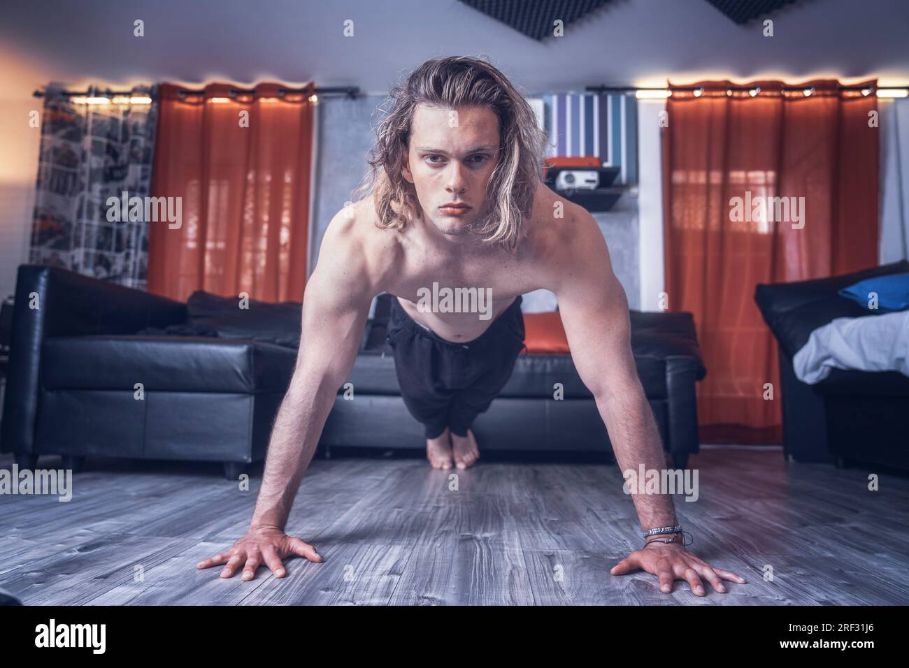 Young model sporty man exercising push up on the floor of his indoor ...