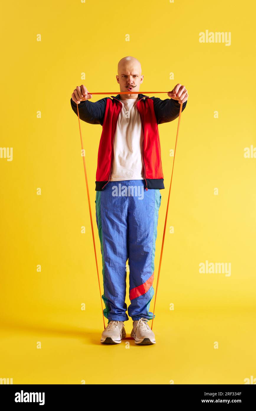 Front view. Full body shoot of man dressed sporty shakes arms with ...