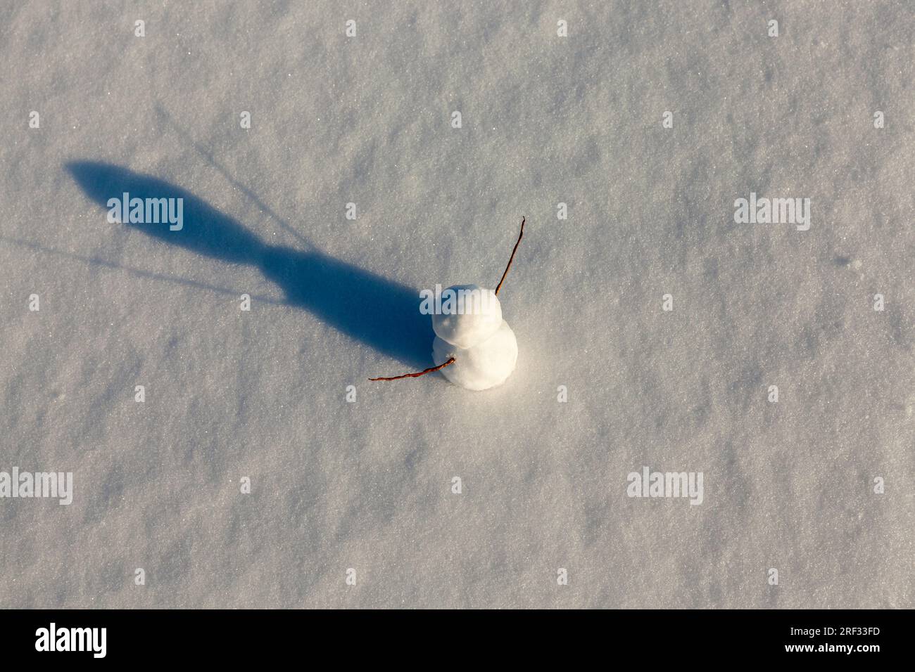 the snowman is made of several parts and stands in the snow in cold ...