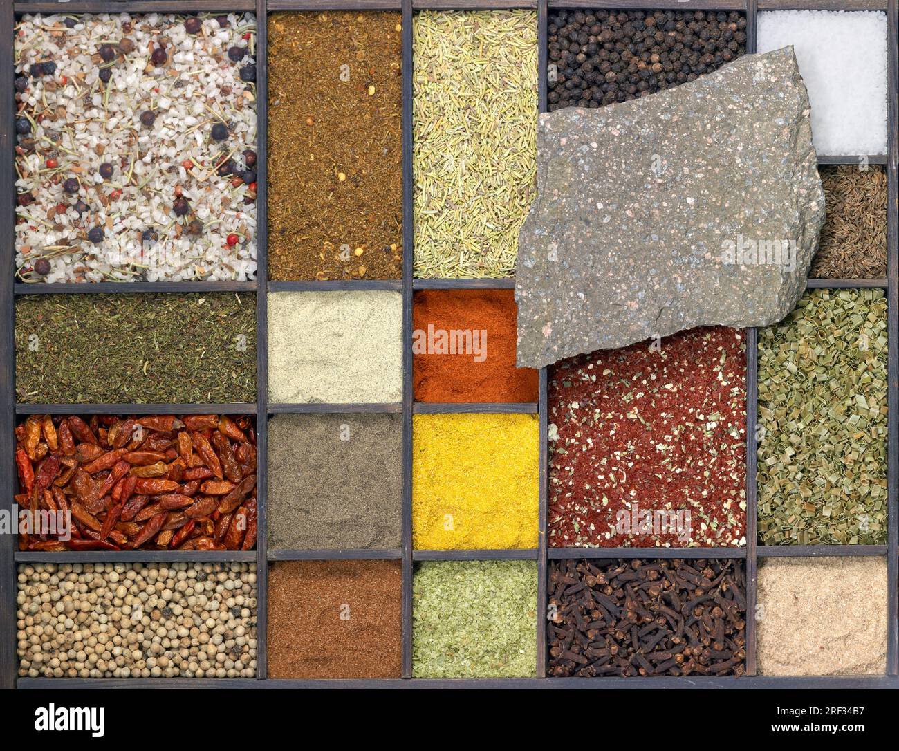 lots of various different spices in a framed dark wooden box with a ...