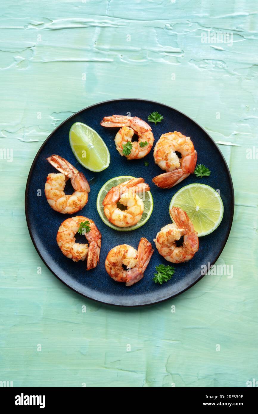 Shrimps, shot from the top on a teal blue background. Cooked shrimp ...