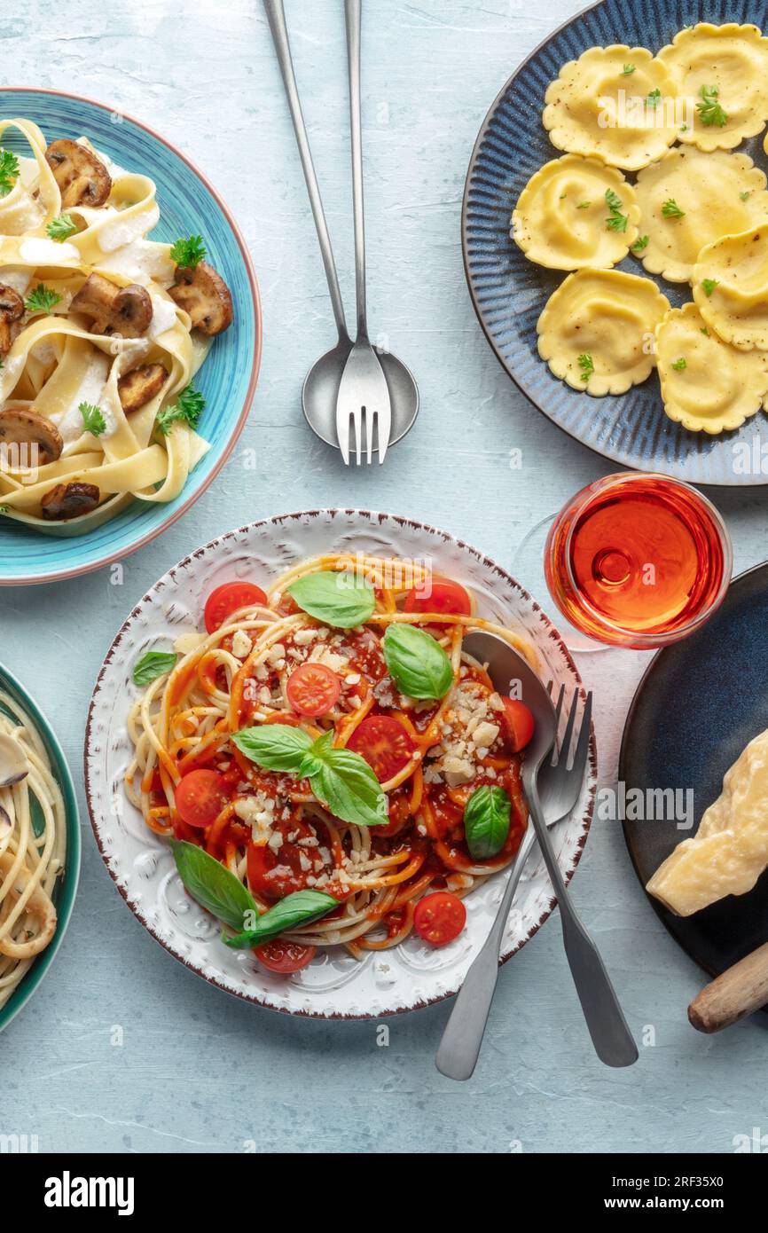 Italian pasta. Spaghetti marinara, mushroom pasta, ravioli, and a glass ...