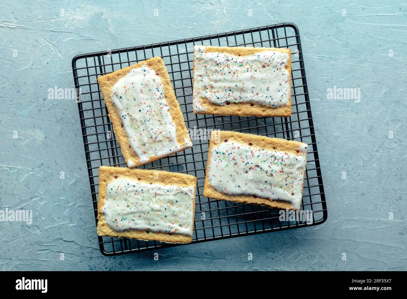 Pop tarts on a baking rack. Poptart toaster pastry with icing on a blue ...