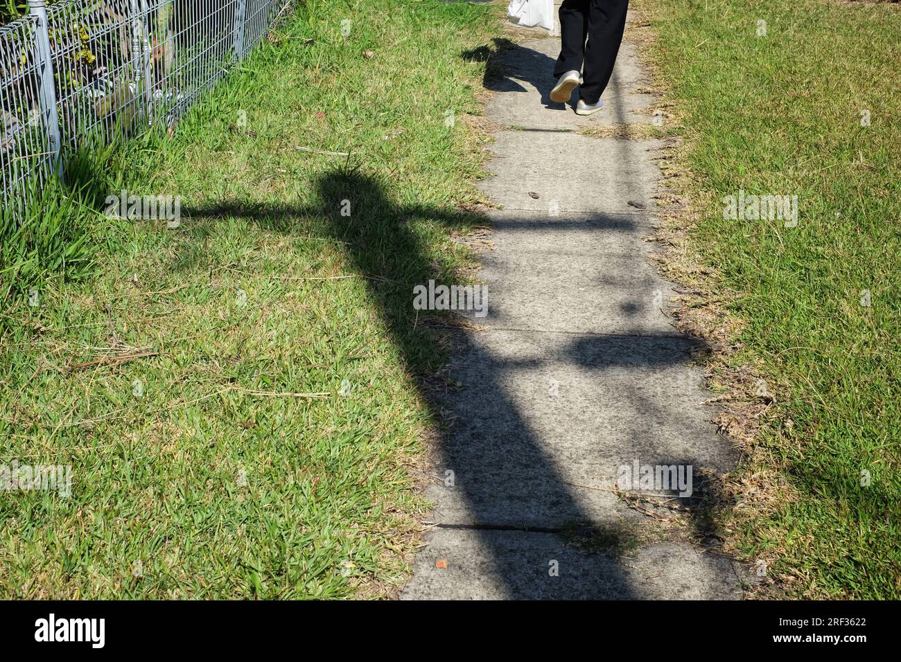 Concrete footpath in Western Sydney with grass strips on either side ...