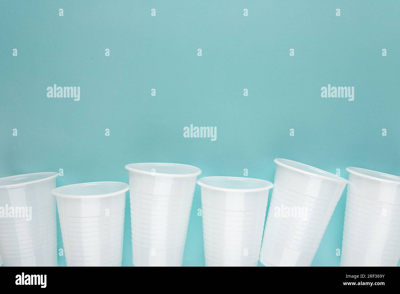 Row of plastic drinking cup on blue background. Eco concept Stock Photo ...