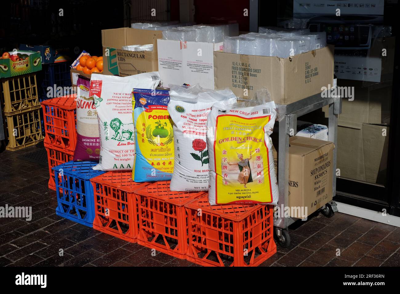 A section of 20 Kilo sacks of rice displayed on milk creates out front ...