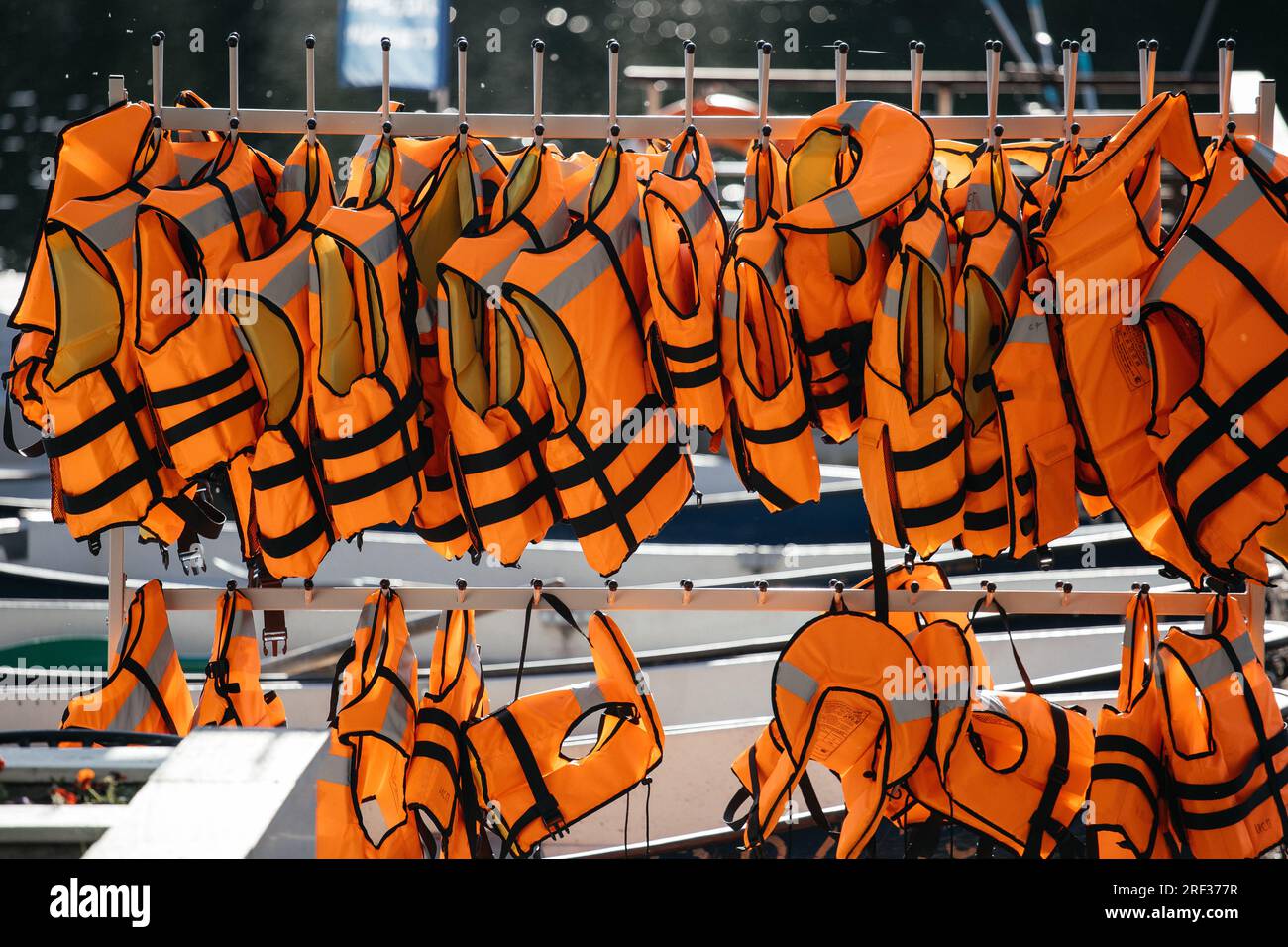 Orange life jacket is a safety device hanging on a steel railings on a ...
