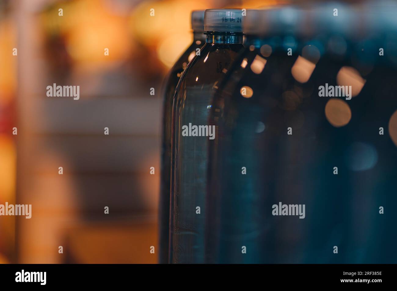 Close up shot of raw water plastics bottles. Line of blue mineral aqua ...