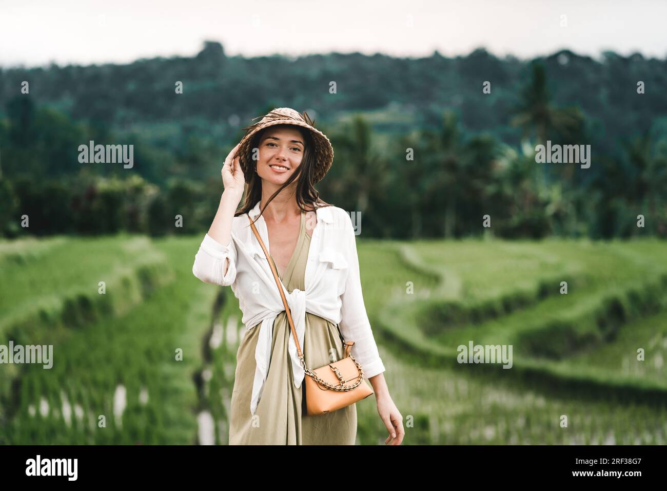 Close up shot of beautiful girl with traditional balinese hat on rice ...