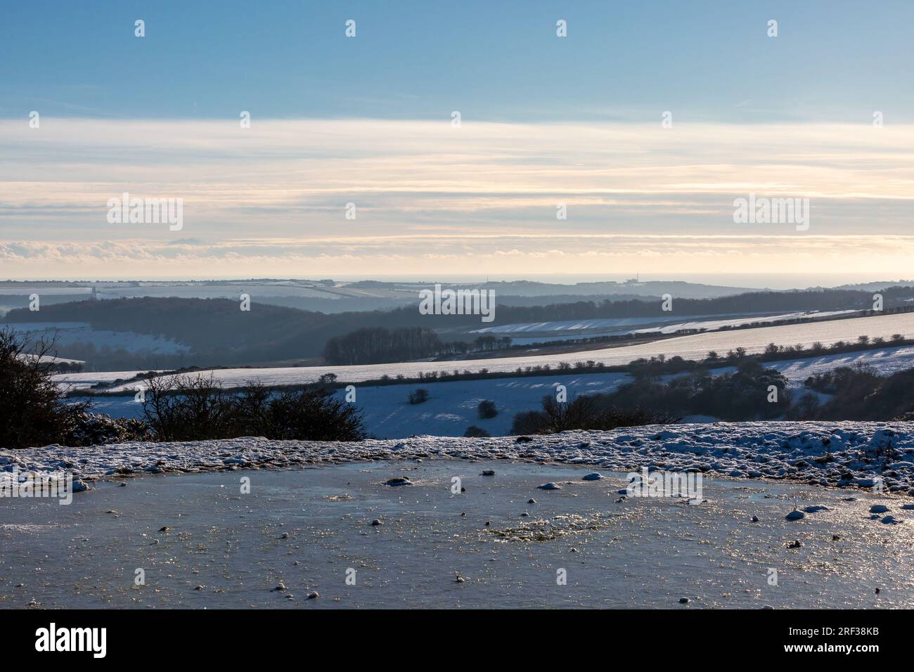 A frozen dew pond on Ditchling Beacon, with snow on the surrounding ...