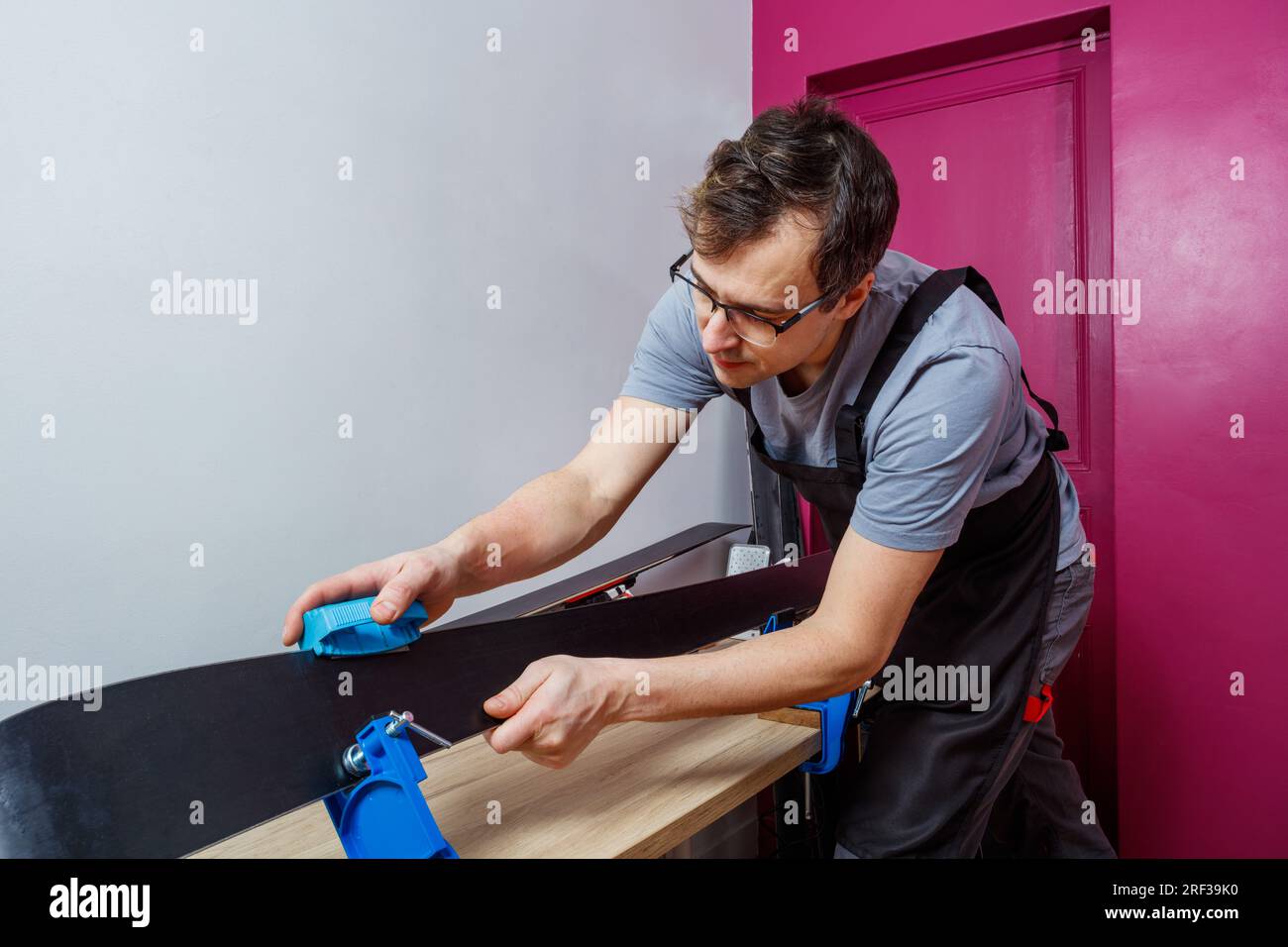 Man wearing apron in a workshop sharp edge of mountain ski Stock Photo ...