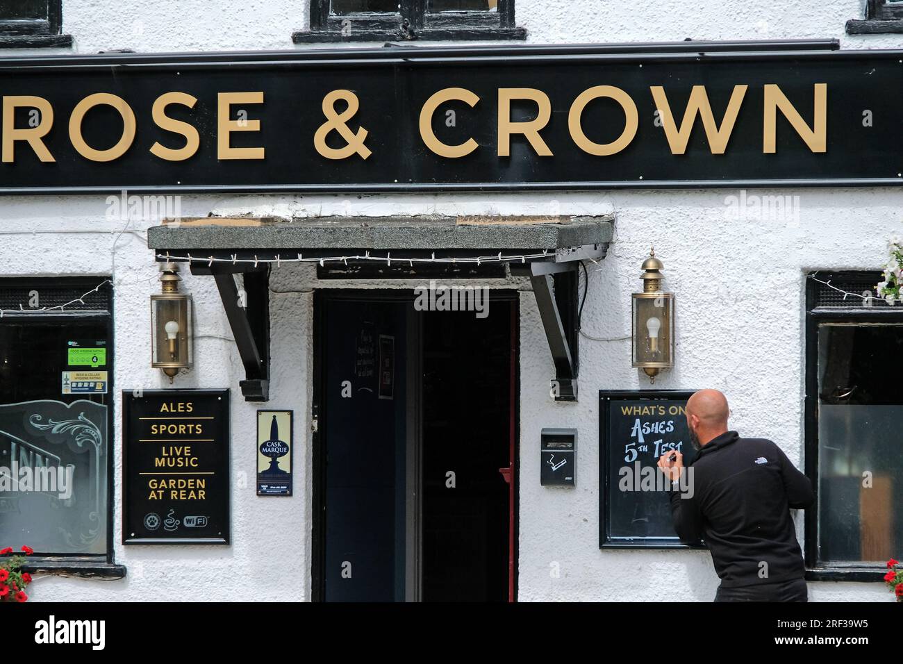 A man writing on a pub 'what's on' sign Stock Photo - Alamy