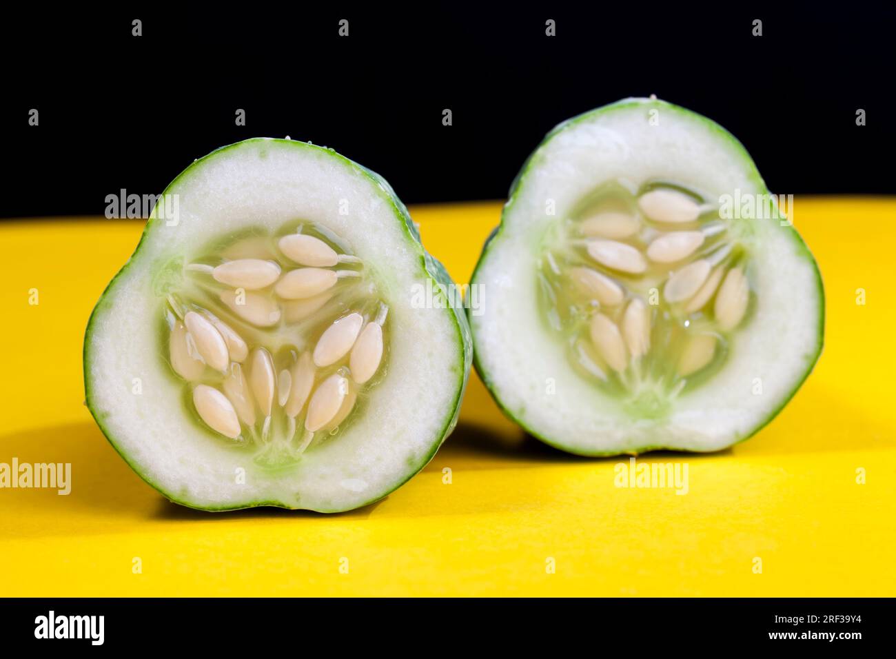 cut into half a ripe old cucumber, the seeds from which can be used to ...