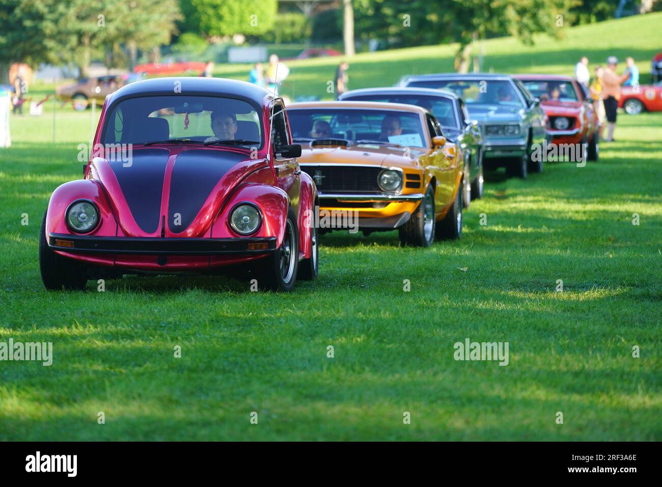 Line-up of cars coming to a car show Stock Photo - Alamy