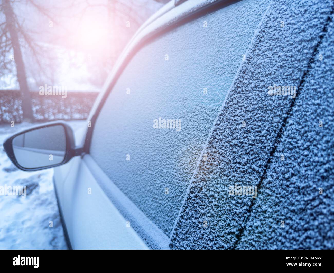 Window of the car covered with frost during winter and sun flare Stock ...