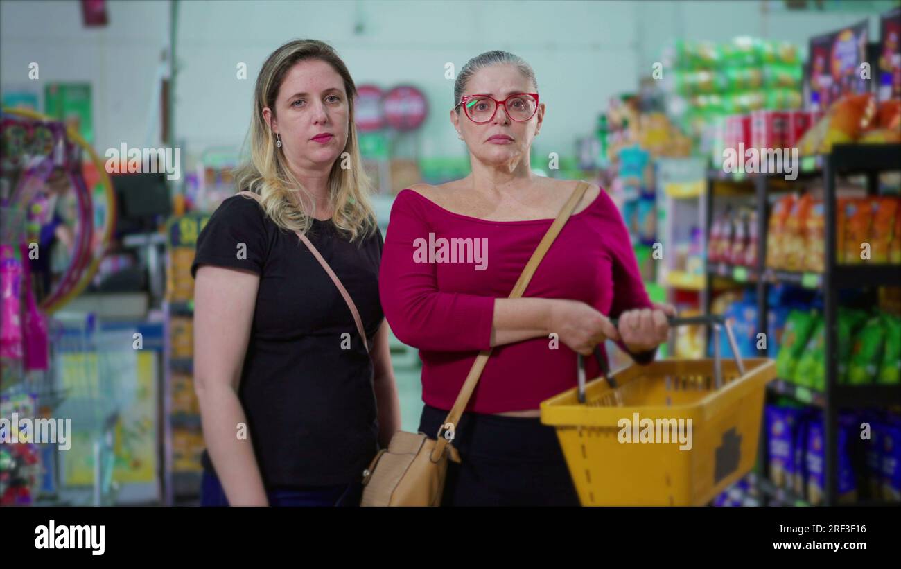 Stern Faced Middle-Aged Female Customers Holding Baskets Inside Grocery ...