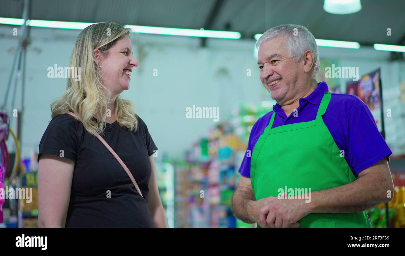 Senior caucasian employee laughing and smiling with female customer ...