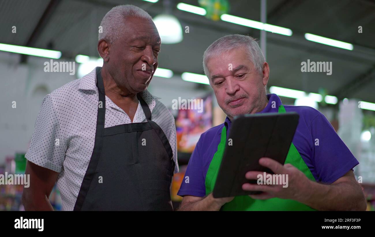 Teamwork at Grocery Store, Older Manager Guiding Employee through ...