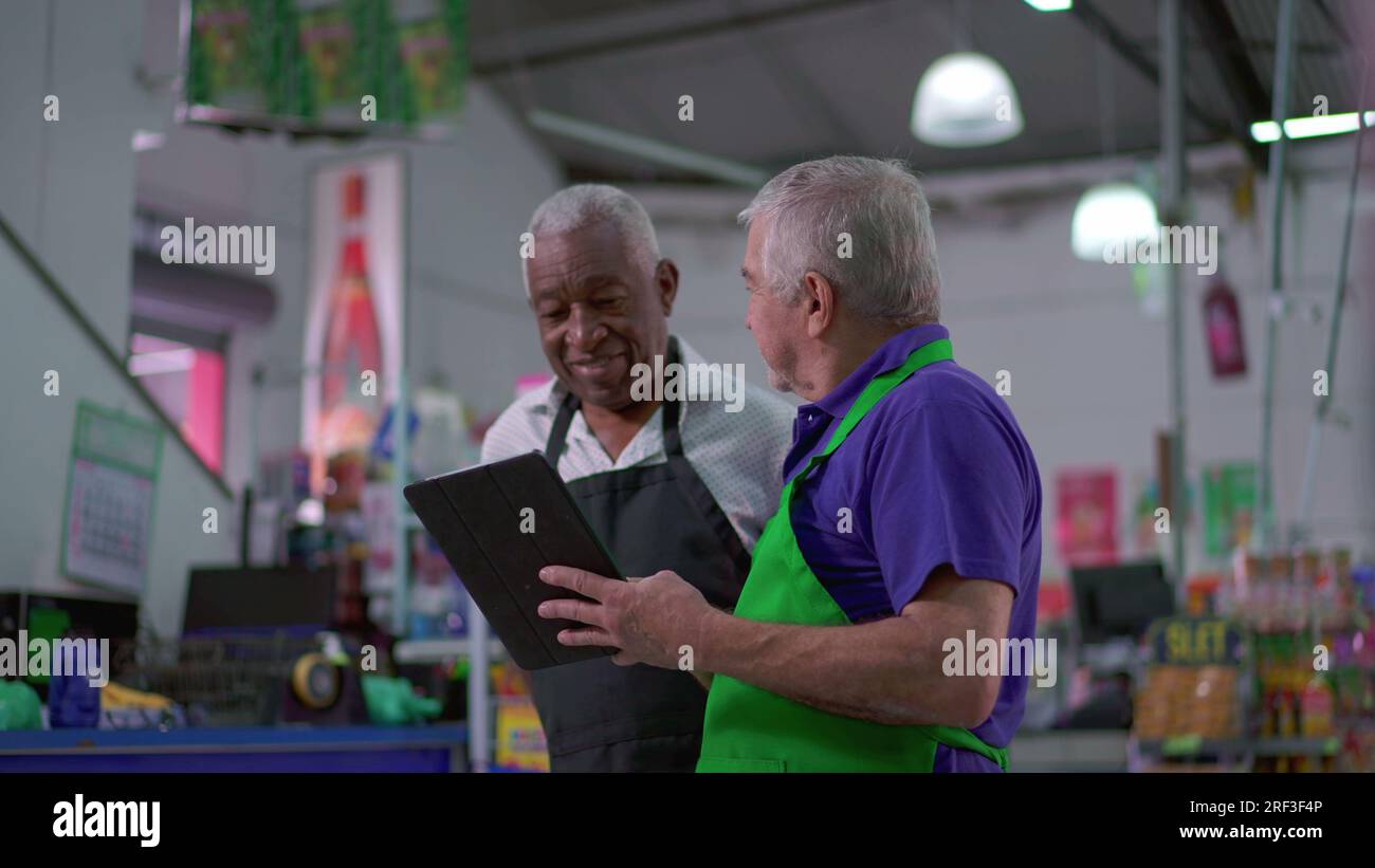 Teamwork at Grocery Store, Older Manager Guiding Employee through ...