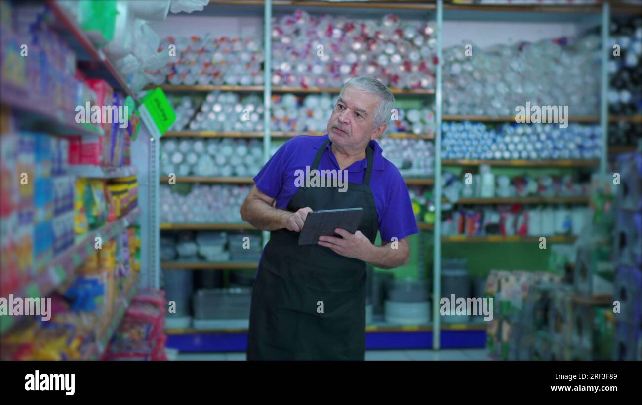 Senior manager of grocery store checking inventory of products on shelf ...