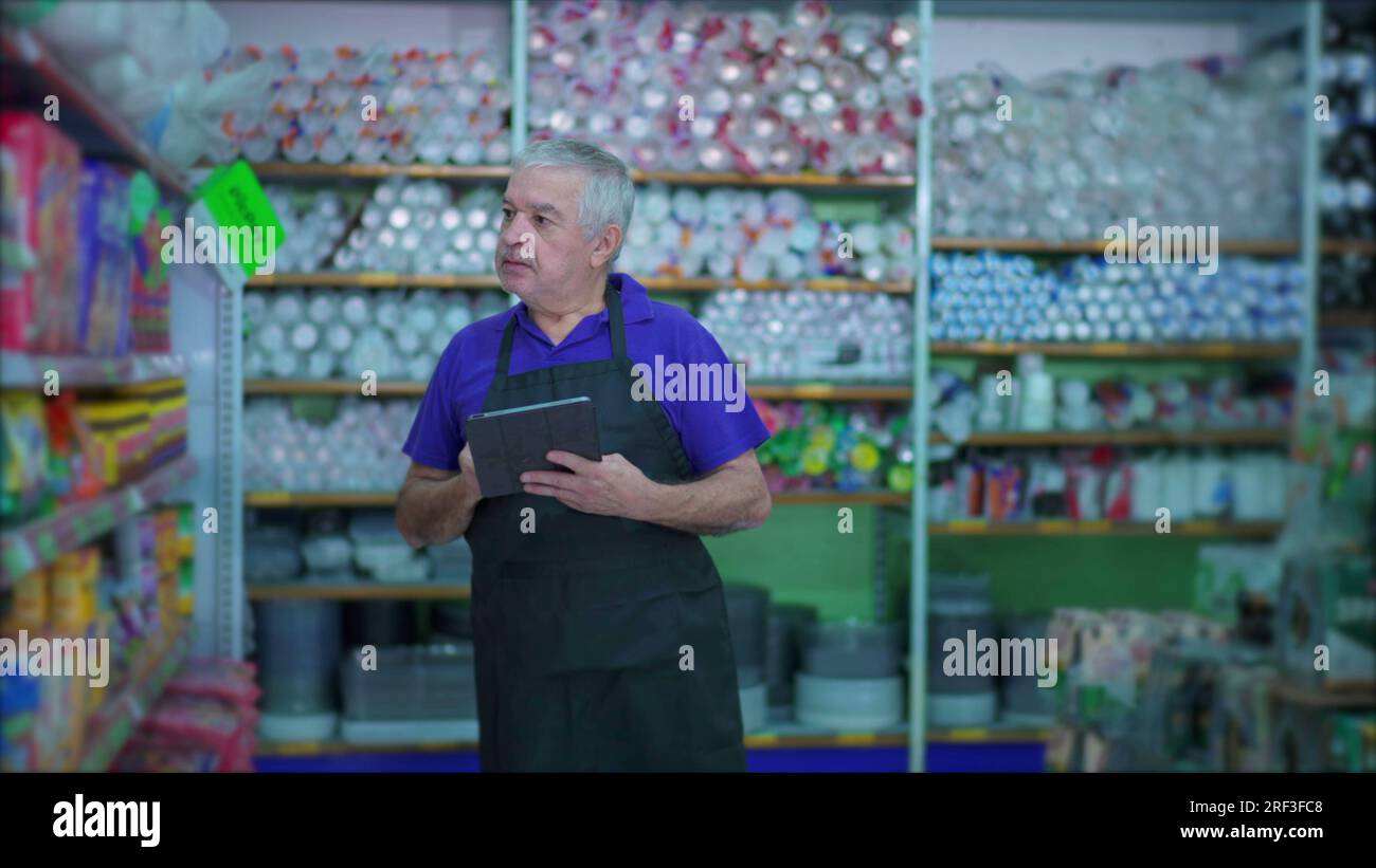 Senior manager of grocery store checking inventory of products on shelf ...