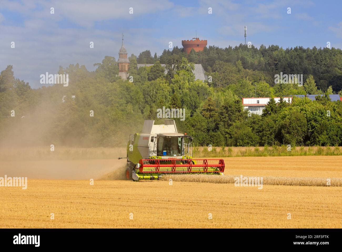 Landscape with farmer working with Claas Tucano 570 combine harvester ...