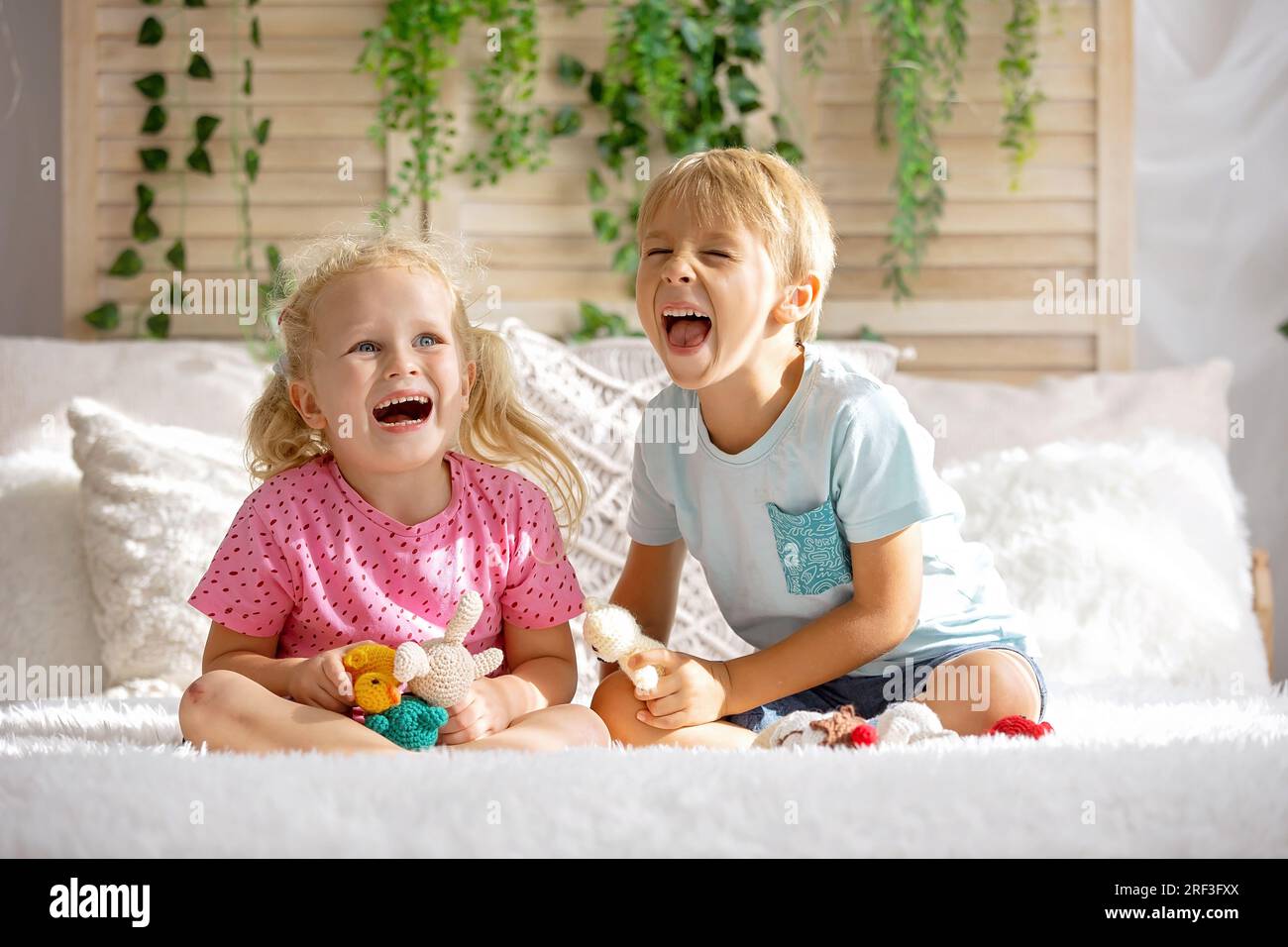 Cute sweet toddler children, tickling feet on the bed, laughing and ...