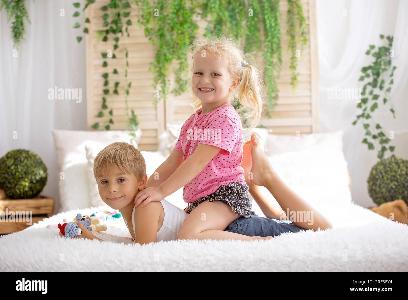 Cute sweet toddler children, tickling feet on the bed, laughing and ...