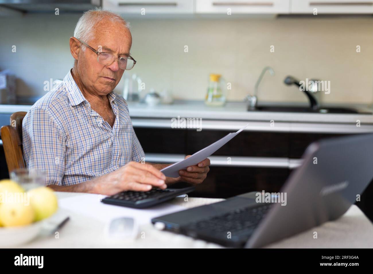 Senior man counting with calculator Stock Photo - Alamy