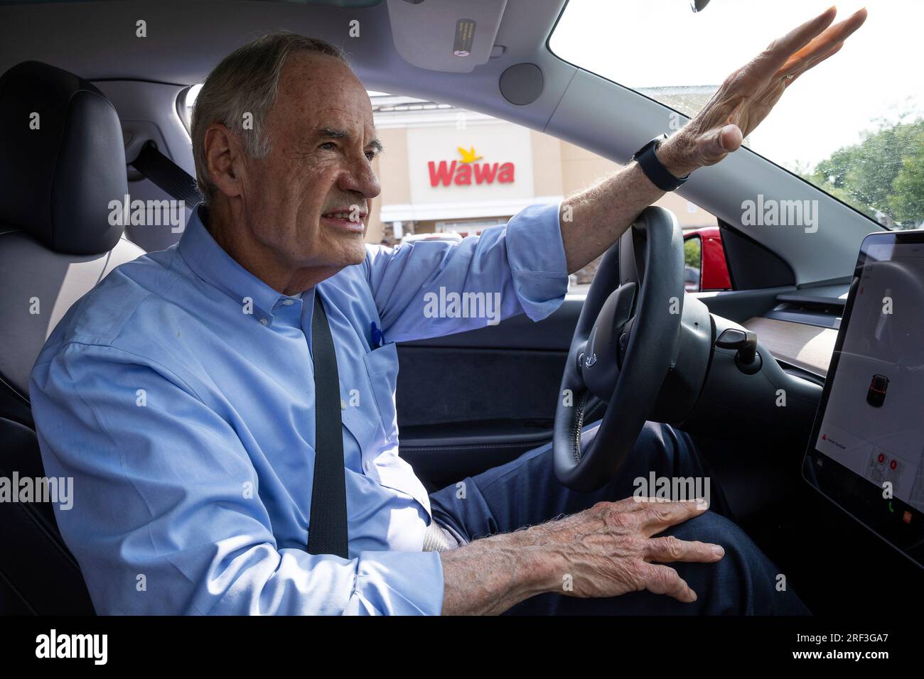 Sen. Tom Carper (D-Del.) waves to people while sitting in the driver's ...
