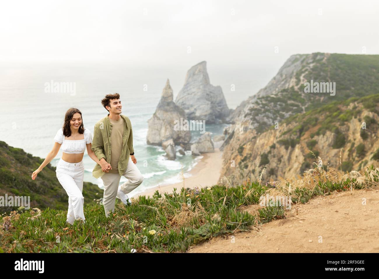Happy european couple in love holding hands while walking on nature ...