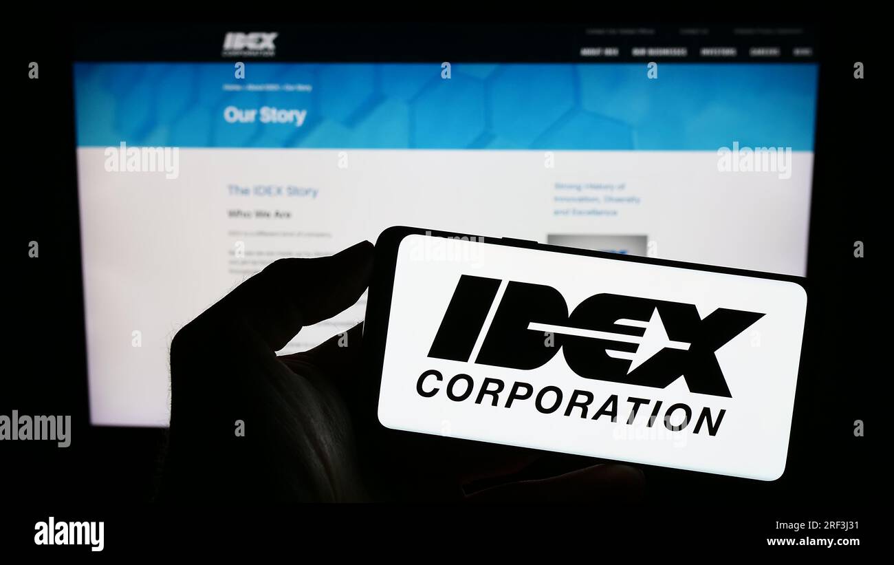 Person holding smartphone with logo of US manufacturing company IDEX ...