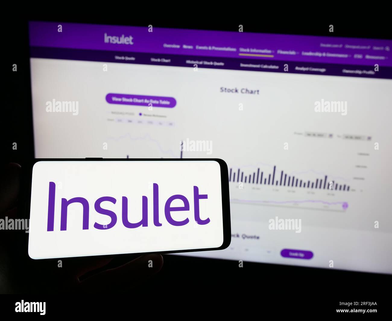 Person holding mobile phone with logo of US medical device company ...