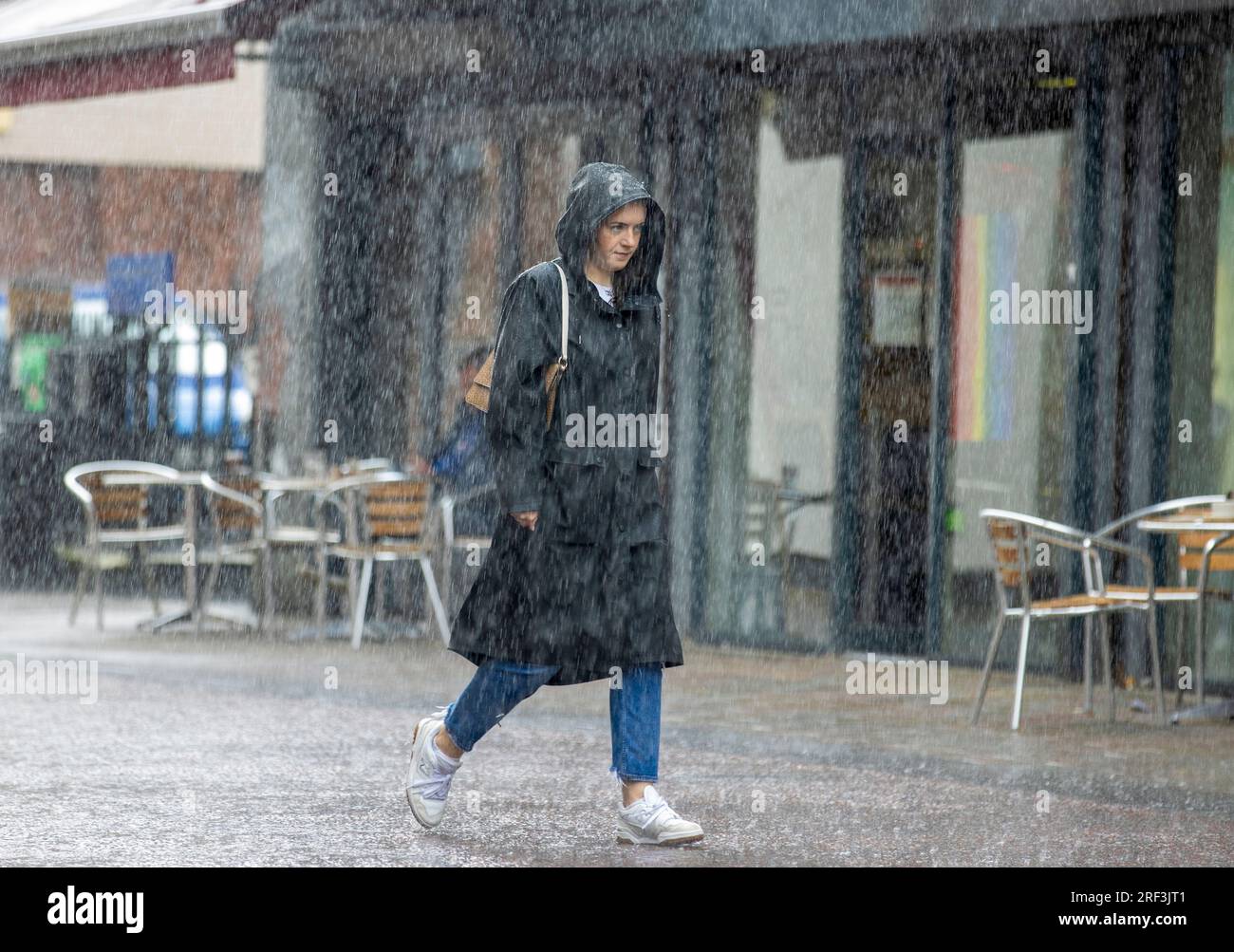 A woman walks down a street during a heavy downpour of rain in Belfast ...
