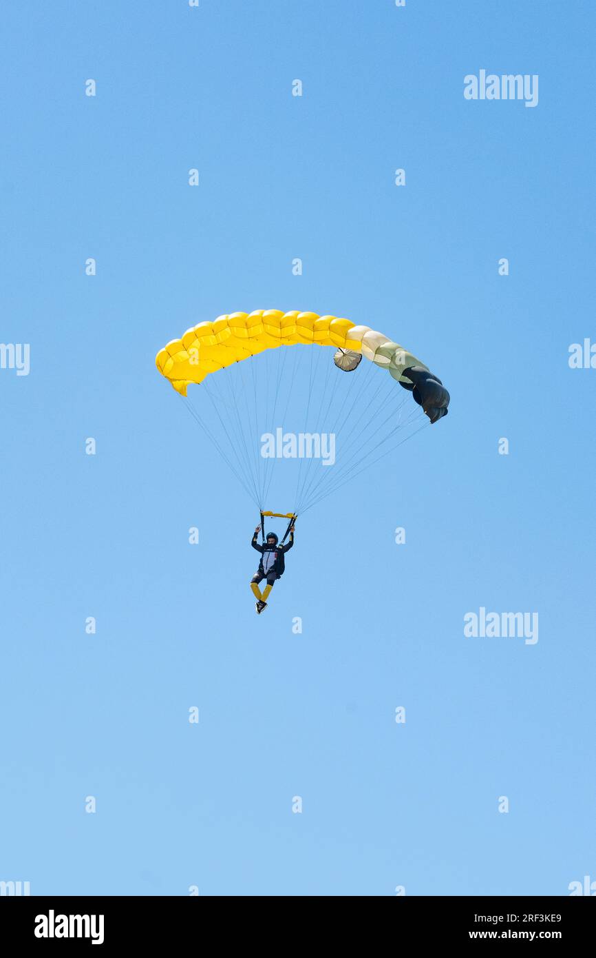 Stunning view of of a skydiver with a yellow parachute and a blue sky ...