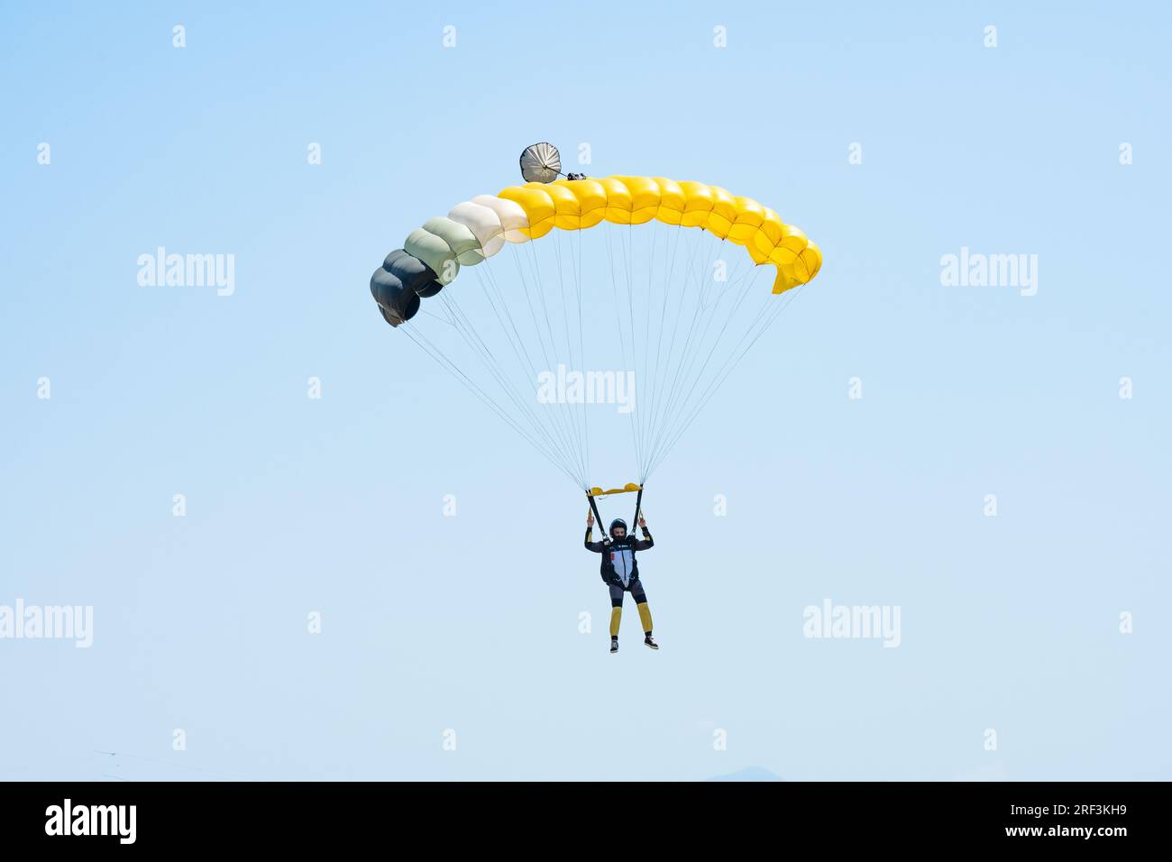 Stunning view of of a skydiver with a yellow parachute and a blue sky ...