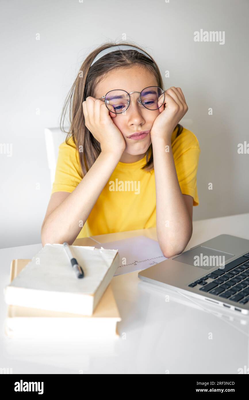 Exhausted schooler girl suffering from doing homework, tired from ...
